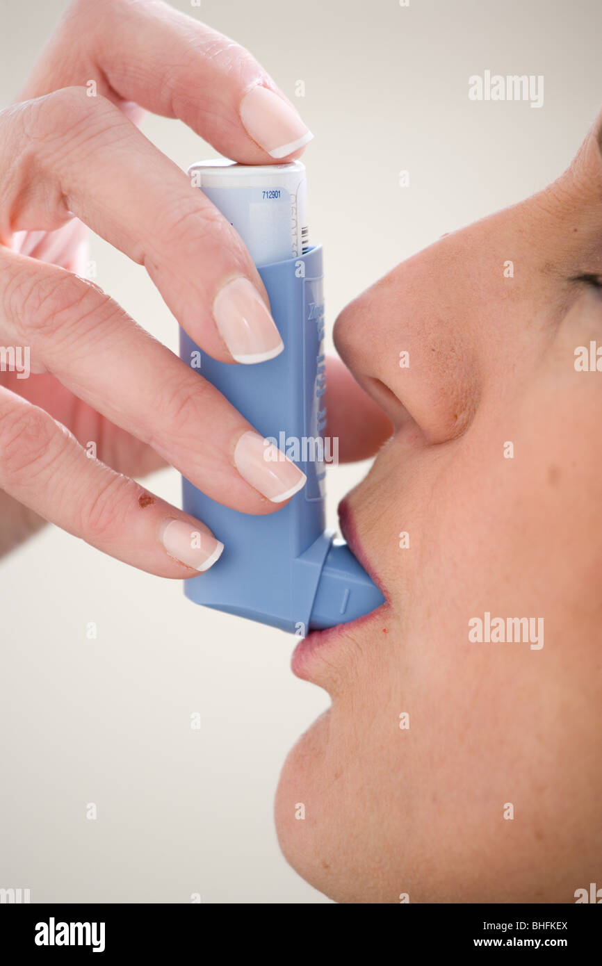 Woman using bronchial dilator to relieve asthma symptoms Stock Photo ...