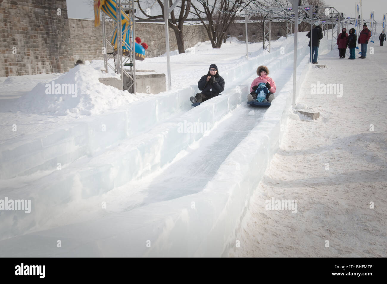 A man rides an ice slide with his wife and his daughter at the Quebec ...