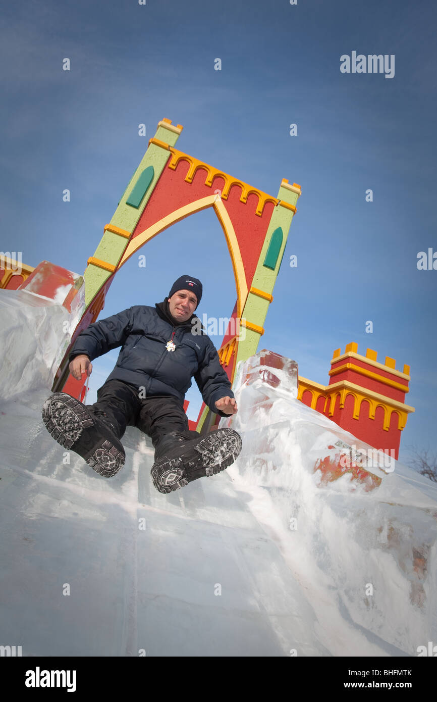 A man rides an ice slide at the Quebec Winter Carnival (Carnaval de ...