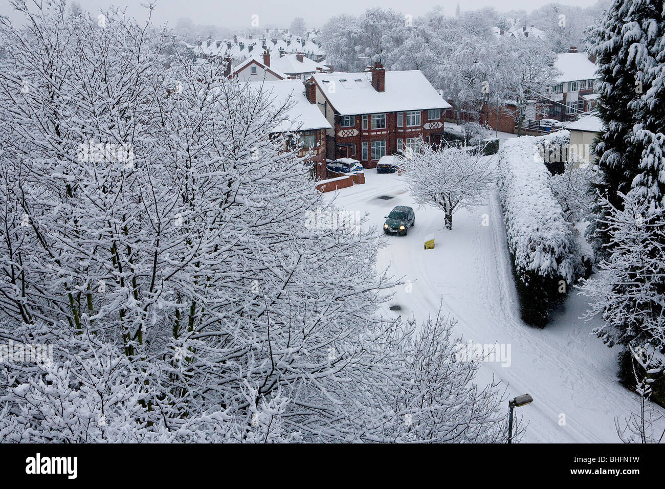 A car rounds a corner in a snow covered village viewed from a high ...