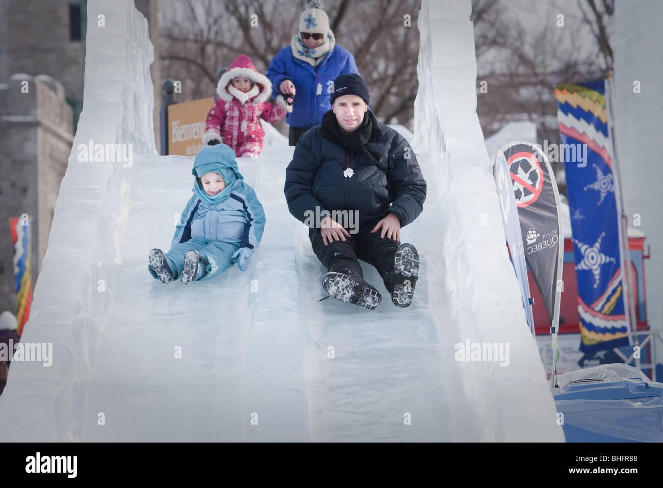 A man looks petrified as he ride an ice slide with daughter at the ...