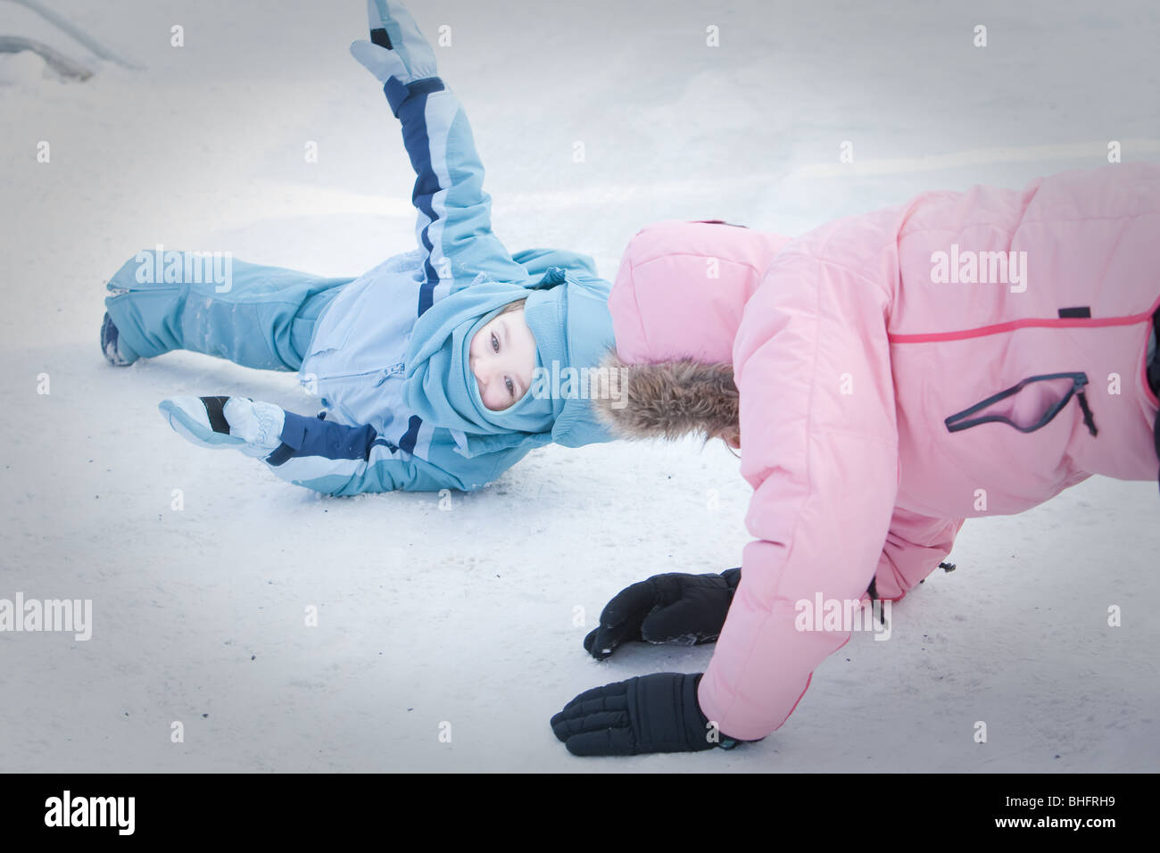 A woman and her daughter fall as they ride an ice slide at the Quebec ...