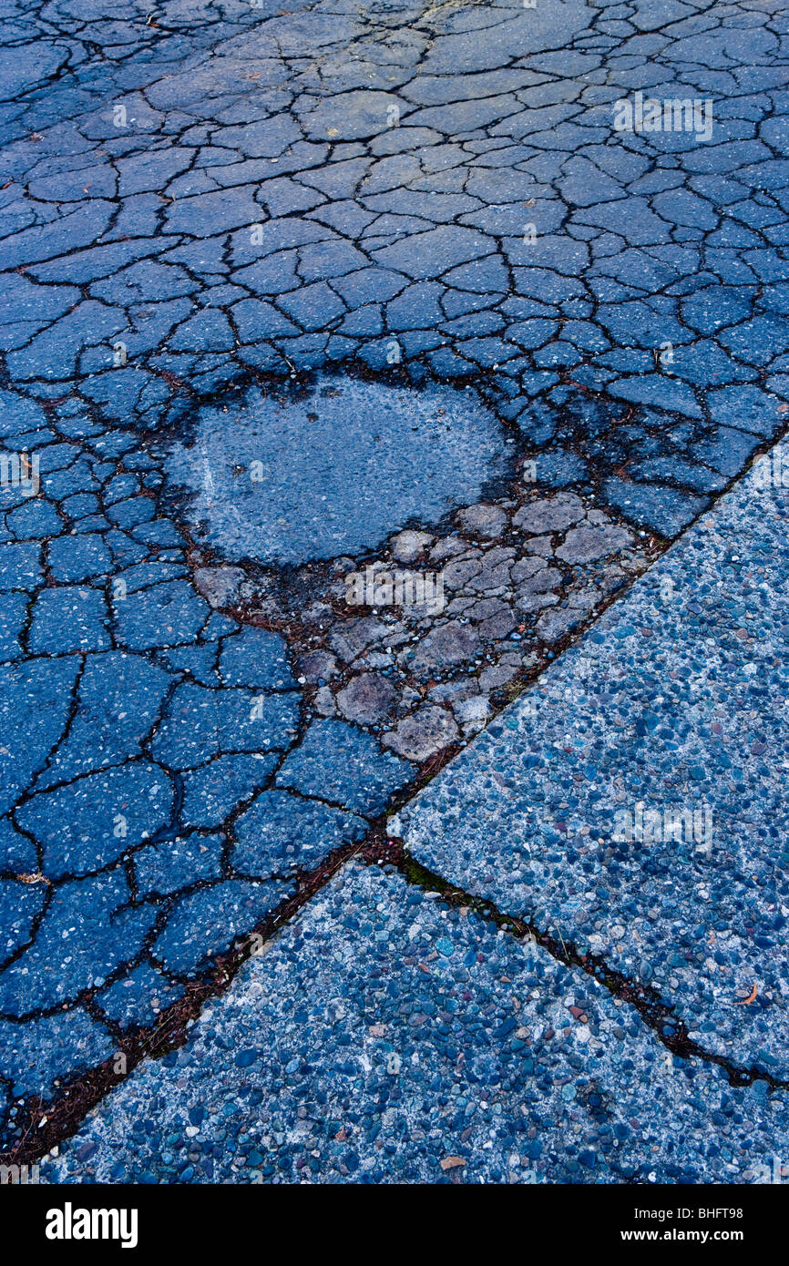 A highly fractured asphalt and concrete parking area Stock Photo - Alamy