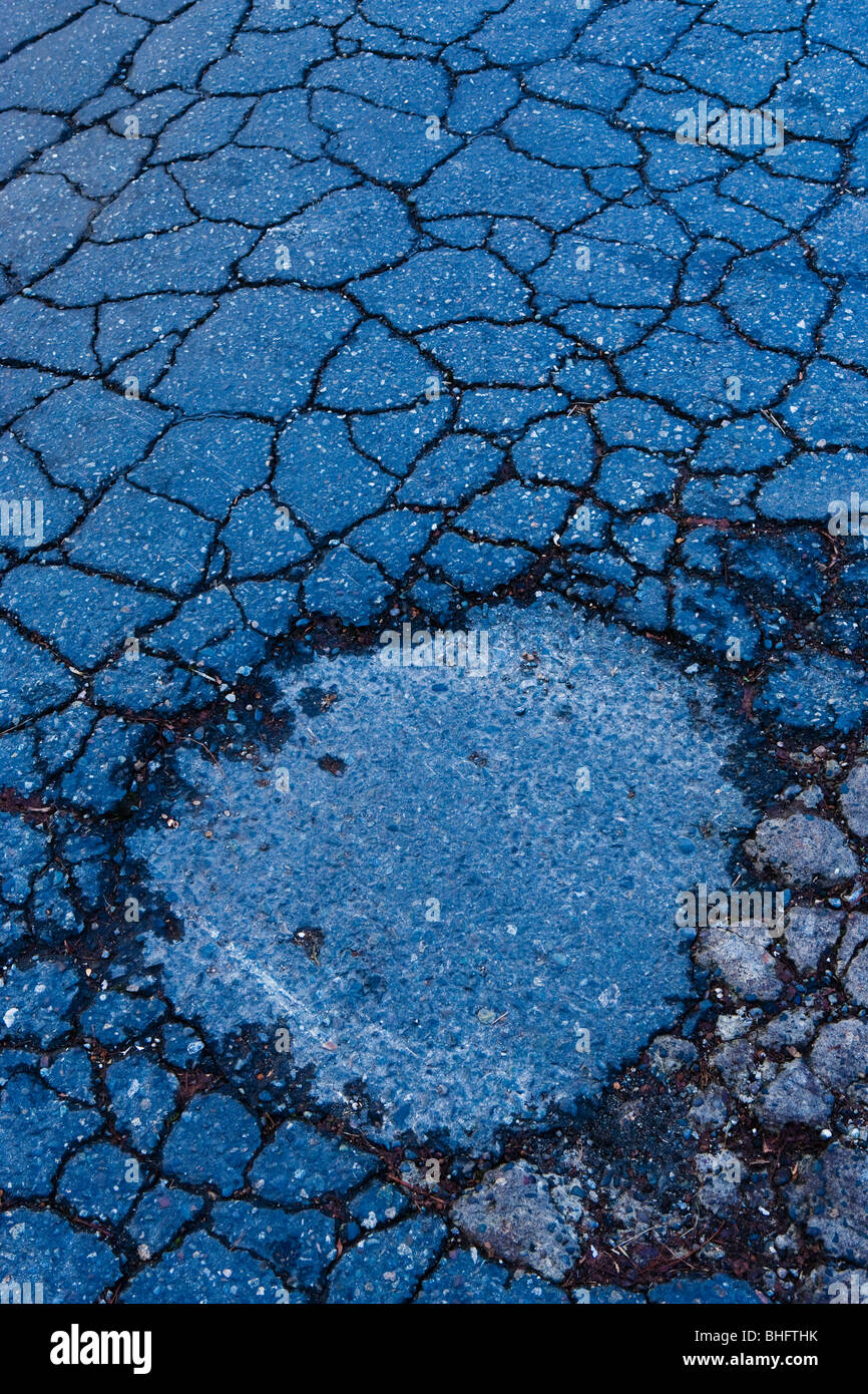 A highly fractured asphalt and concrete parking area Stock Photo - Alamy