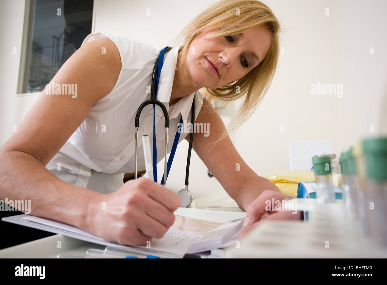 Female doctor writing notes in office Stock Photo - Alamy