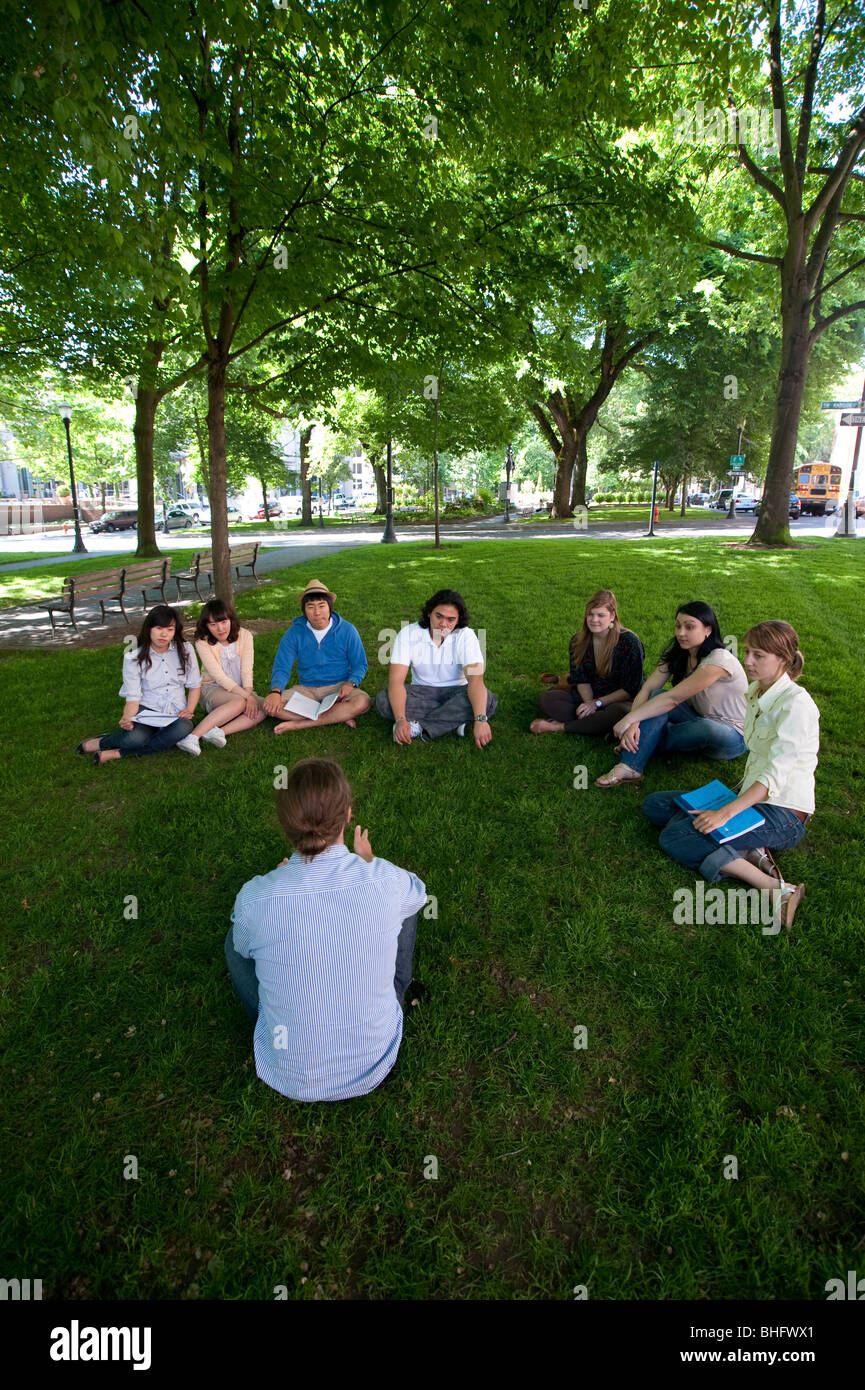 Teacher holding a class with students on lawn of campus Stock Photo - Alamy