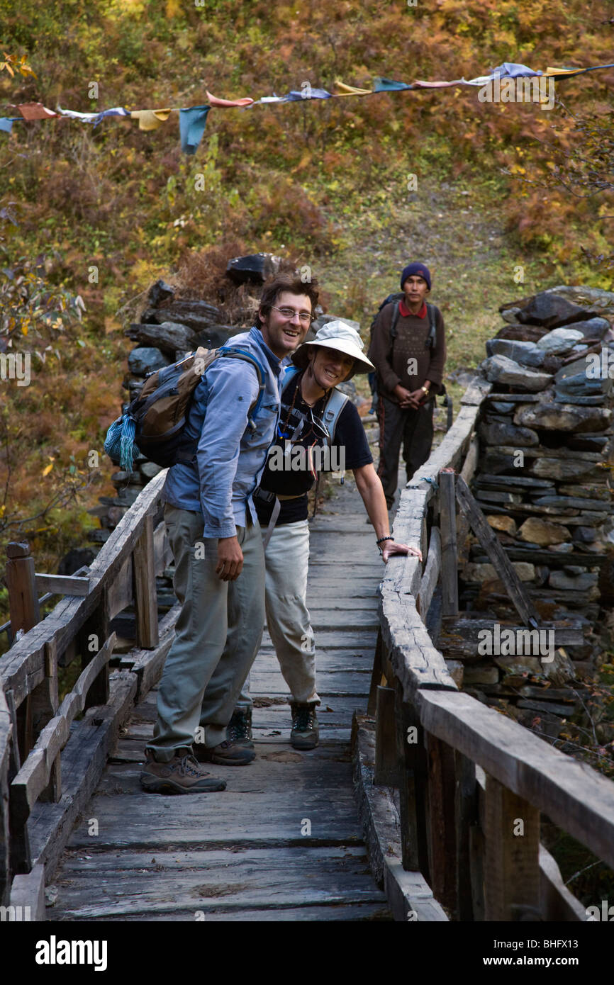 Bodhi Garrett and Christine Kolisch cross a rickety foot bridge with a ...