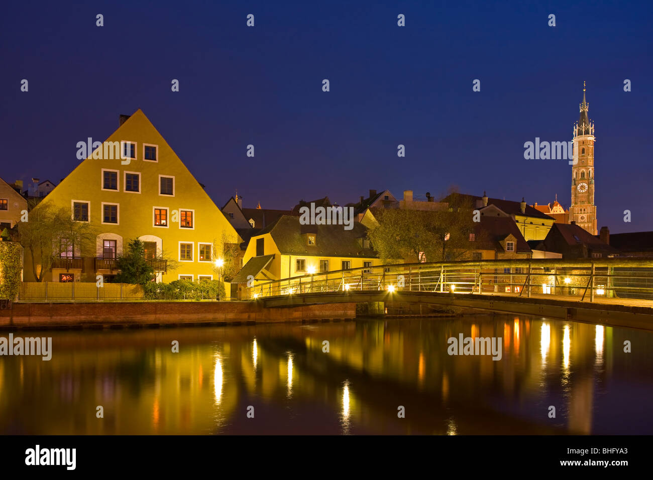 Buildings illuminated at night along the banks of the Isar River with ...