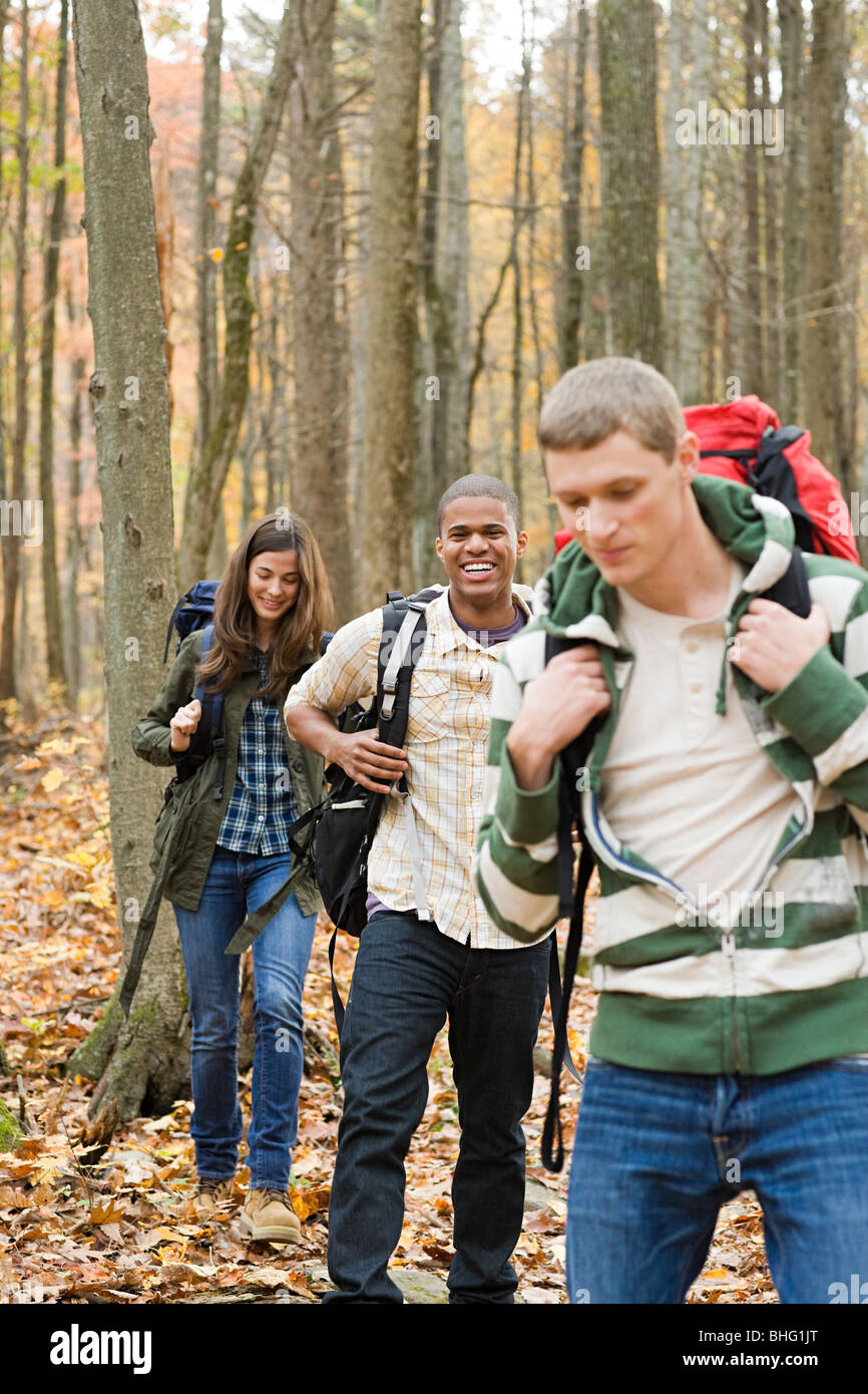 Young people hiking through forest Stock Photo - Alamy