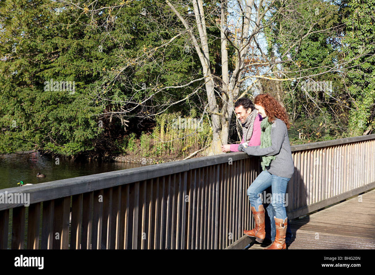 A couple look out over the water from a bridge Stock Photo - Alamy