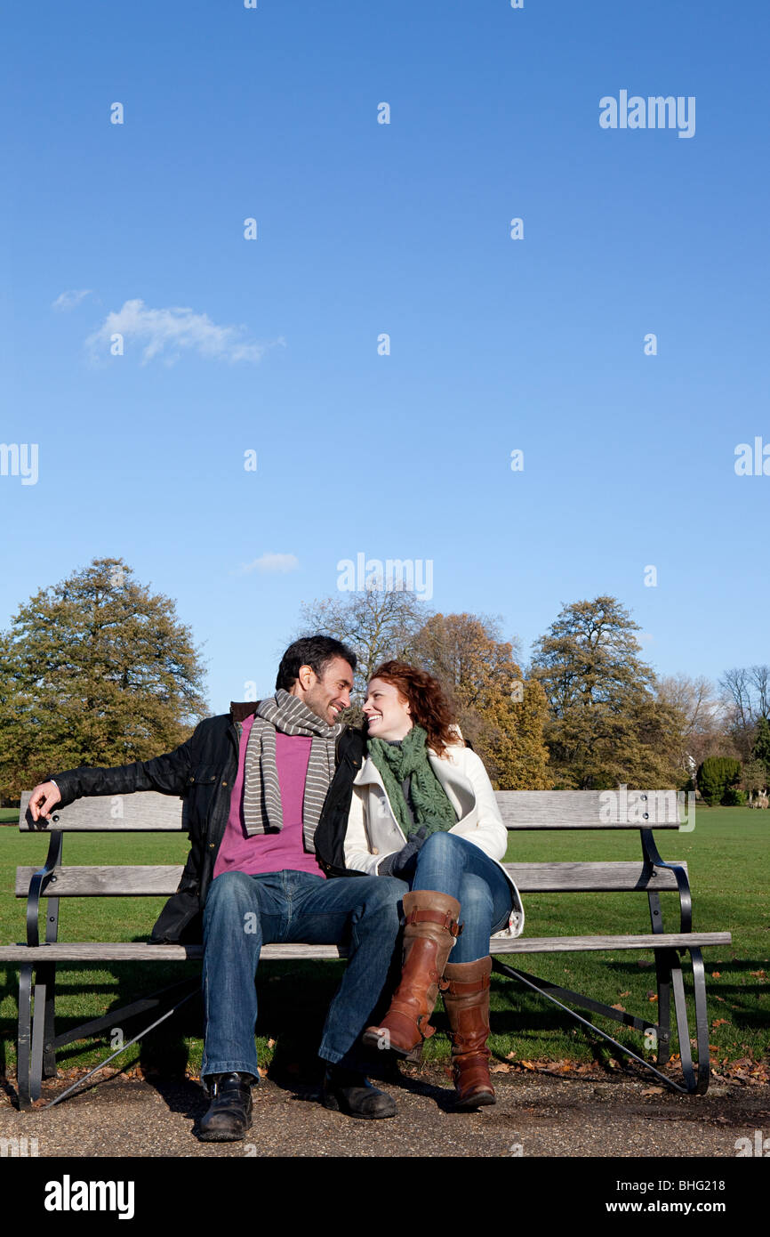 A couple face to face sitting on a park bench Stock Photo - Alamy
