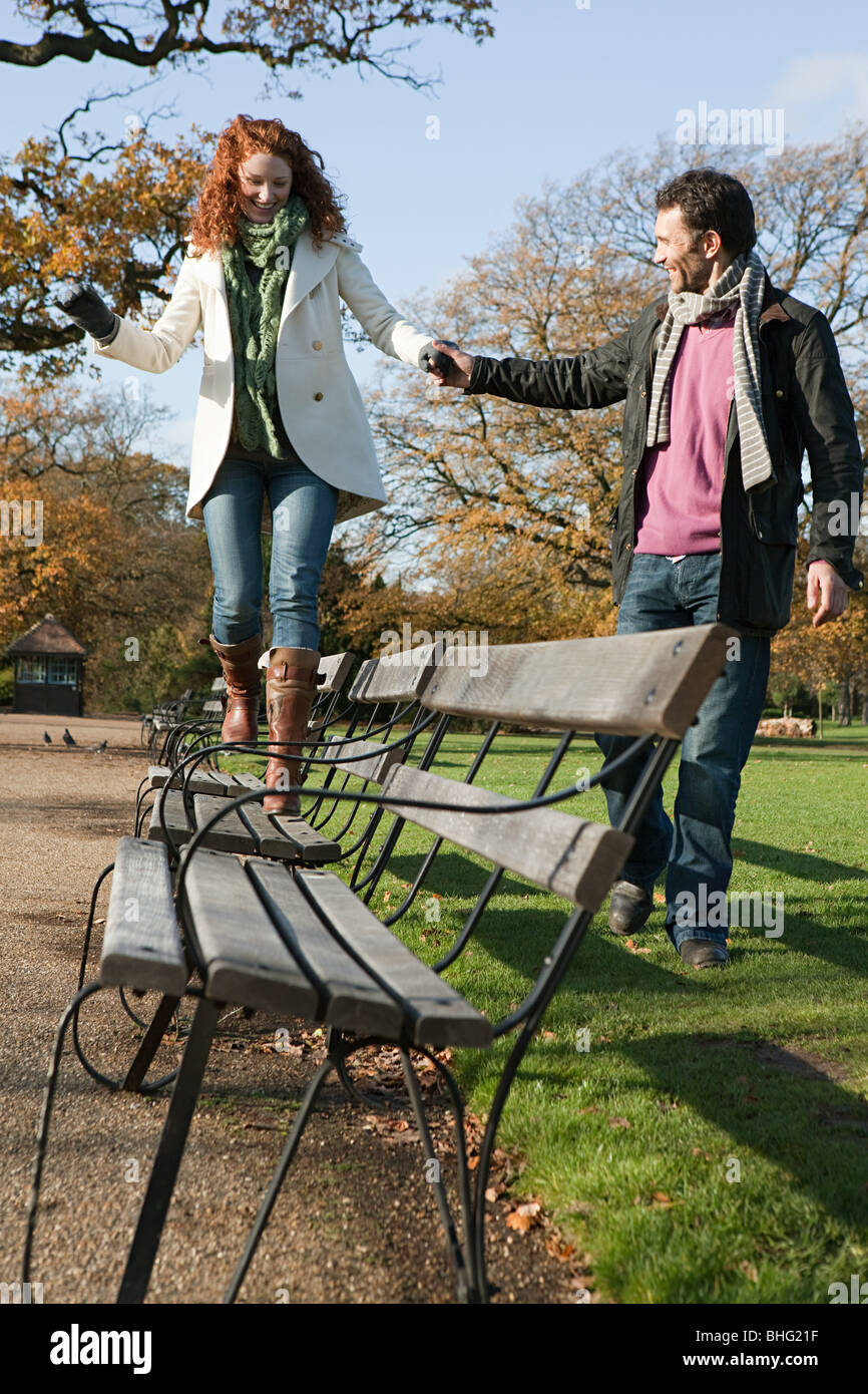 A woman walking across a park bench Stock Photo - Alamy