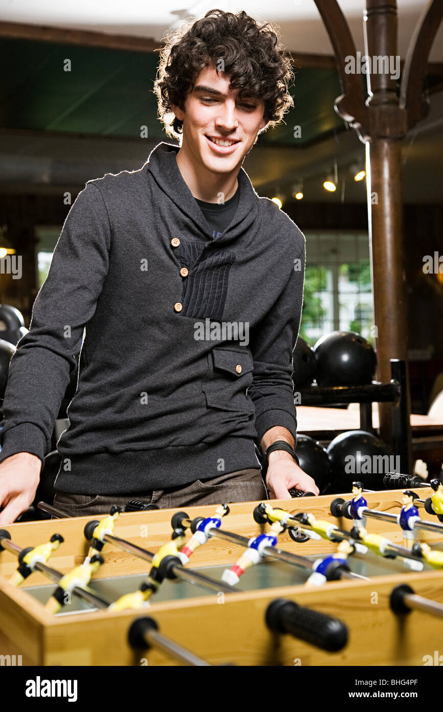 Young man playing table football Stock Photo - Alamy