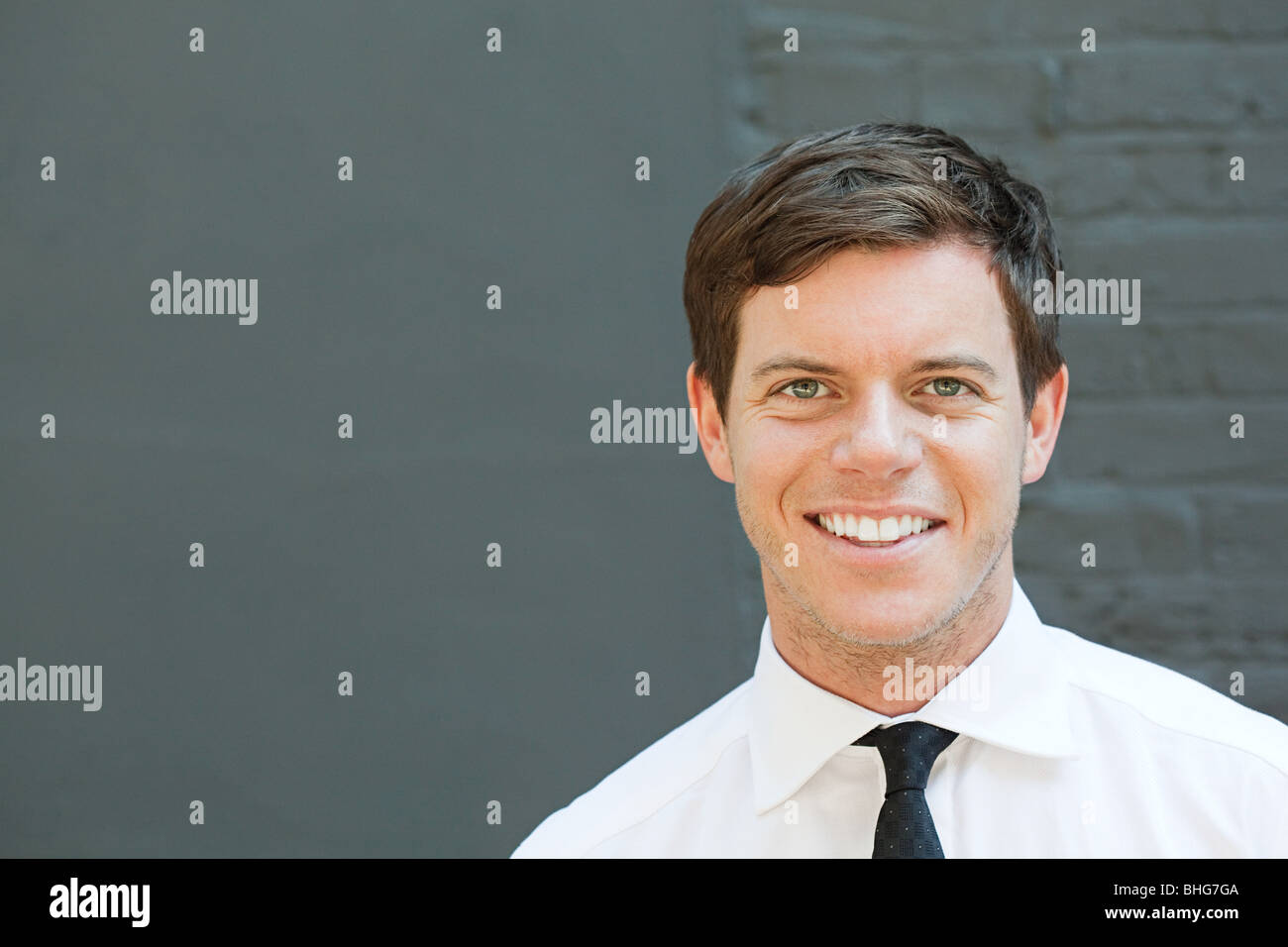 Portrait of young man in front of wall Stock Photo - Alamy