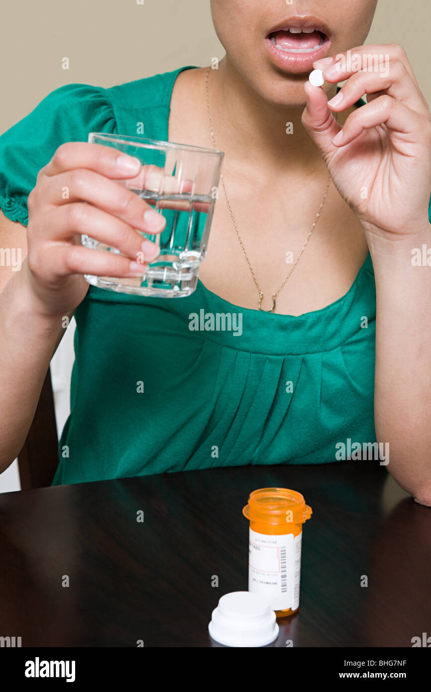 Woman taking tablets Stock Photo - Alamy