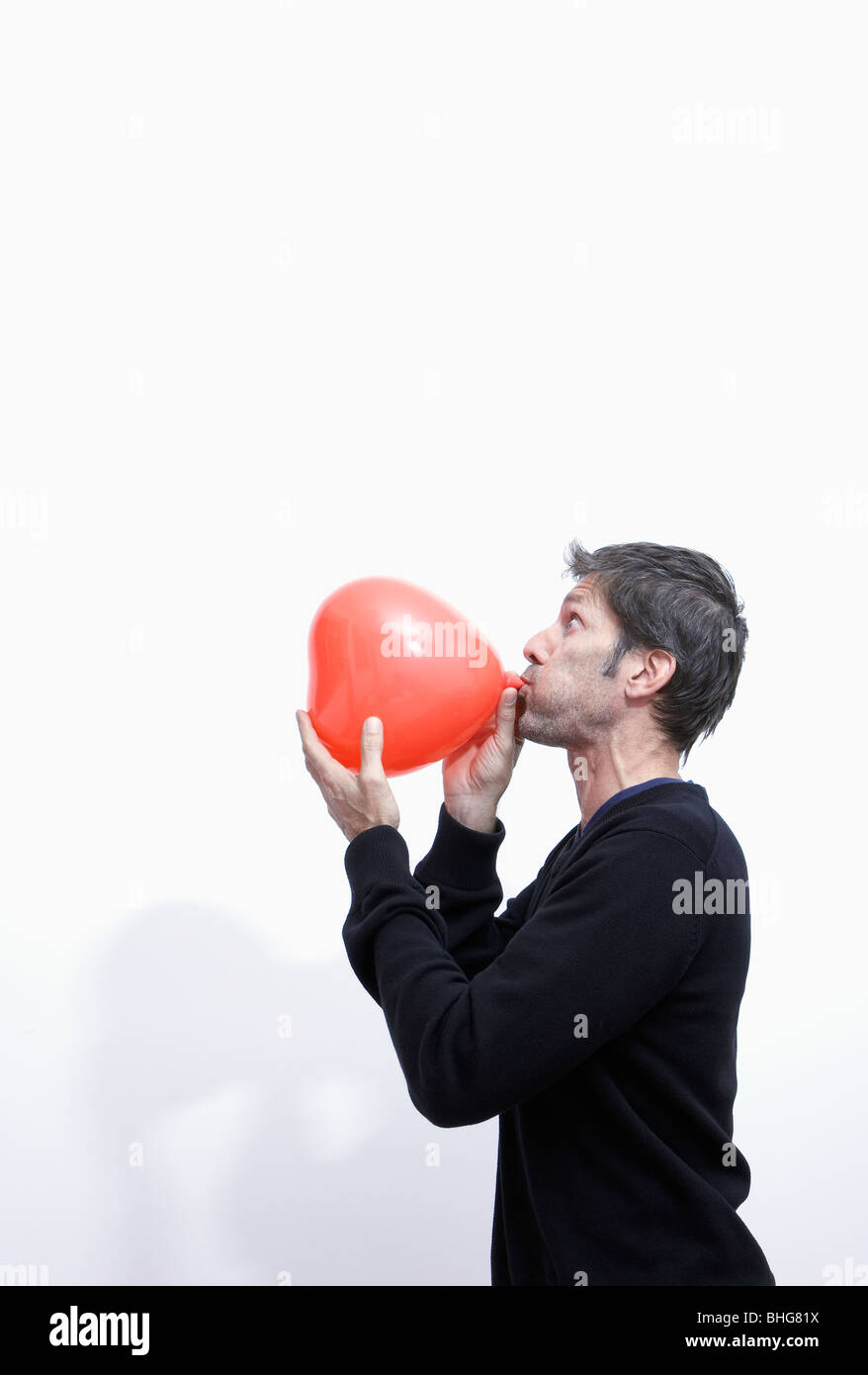 man inflating a heart balloon Stock Photo - Alamy