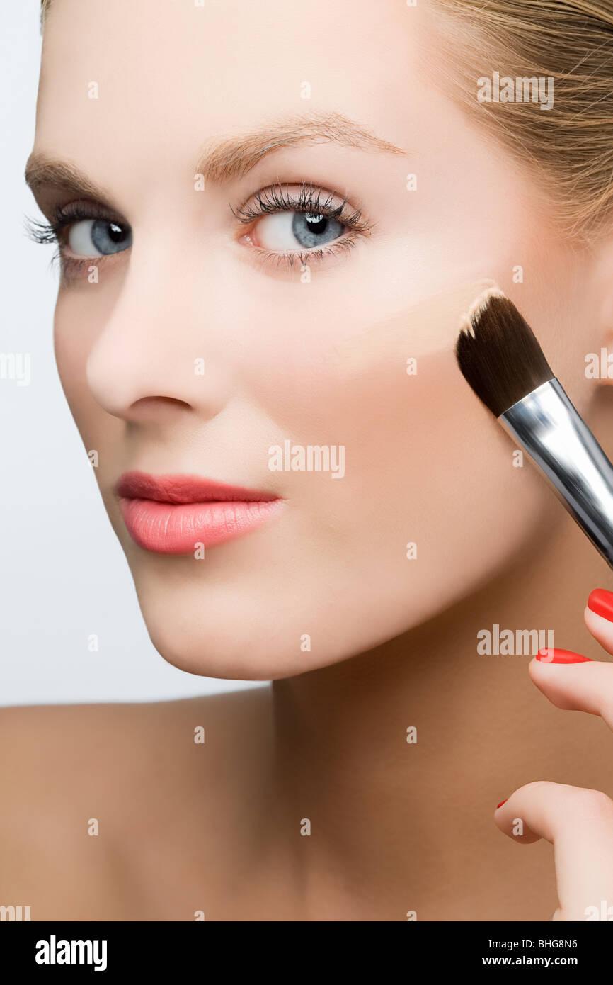 Woman applying foundation Stock Photo - Alamy