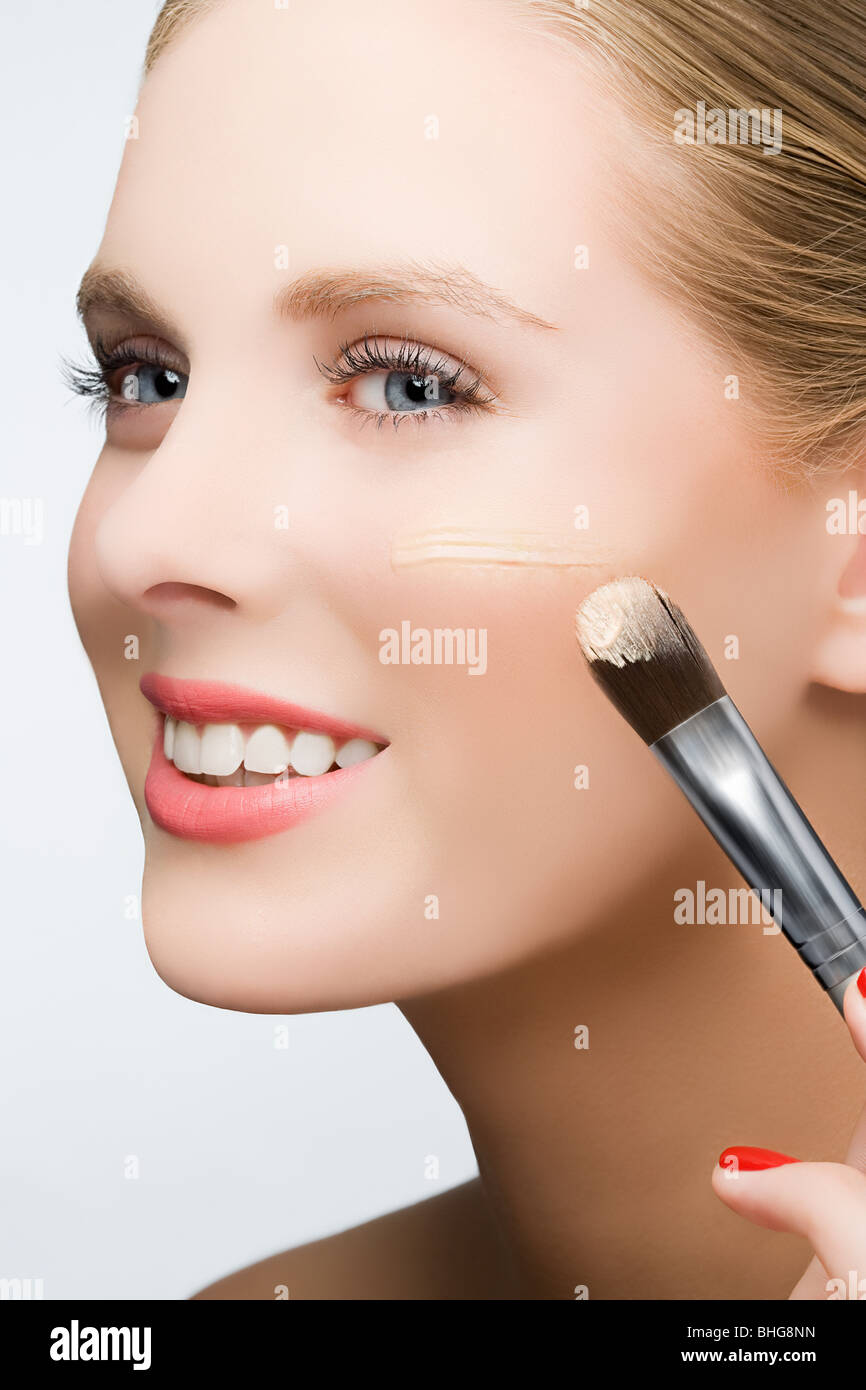 Woman applying foundation Stock Photo - Alamy