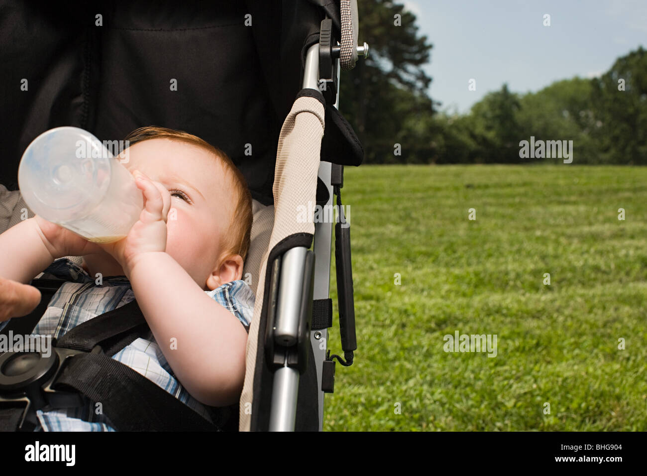 Baby in push chair with bottle Stock Photo - Alamy