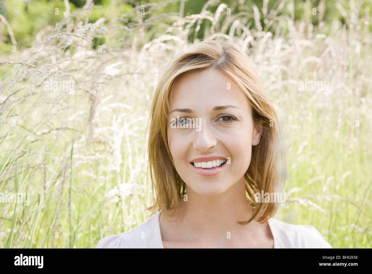 Woman in a field of grass Stock Photo - Alamy
