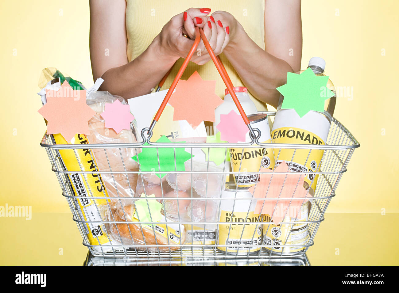 Woman with basic groceries in basket Stock Photo - Alamy