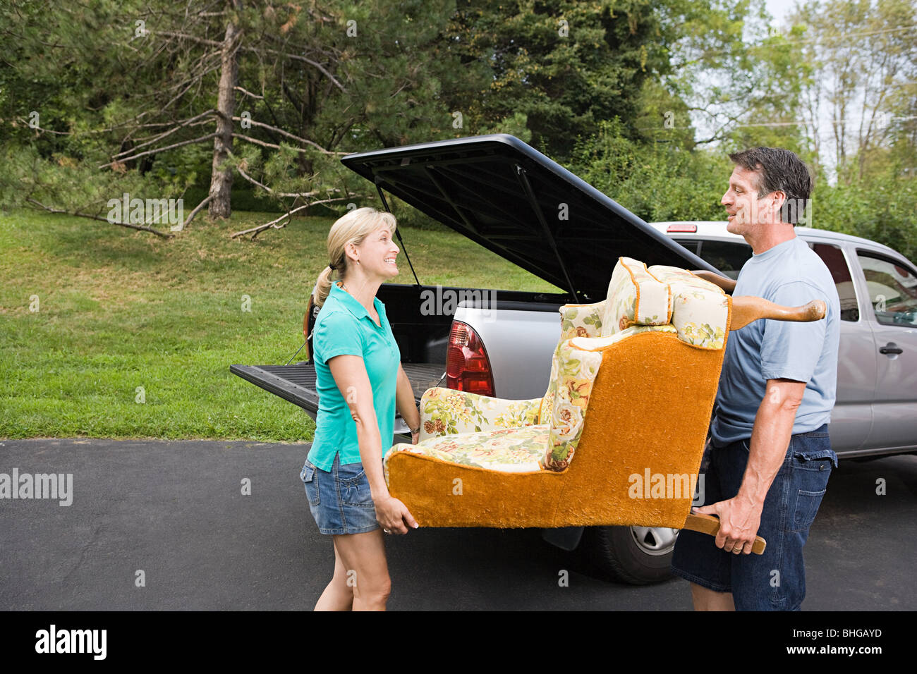 Couple moving armchair Stock Photo - Alamy