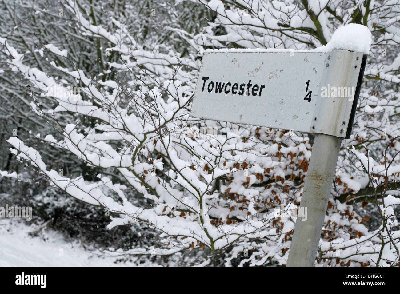 Snow covered road sign pointing towards Towcester Stock Photo - Alamy
