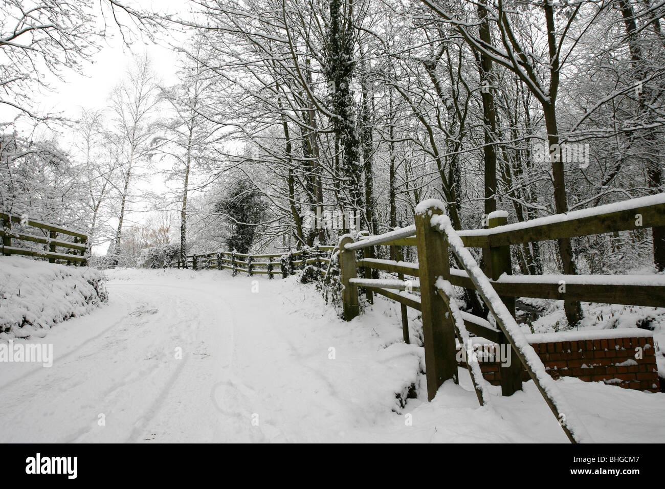 Snow covered country lane over small bridge in woodland Stock Photo - Alamy