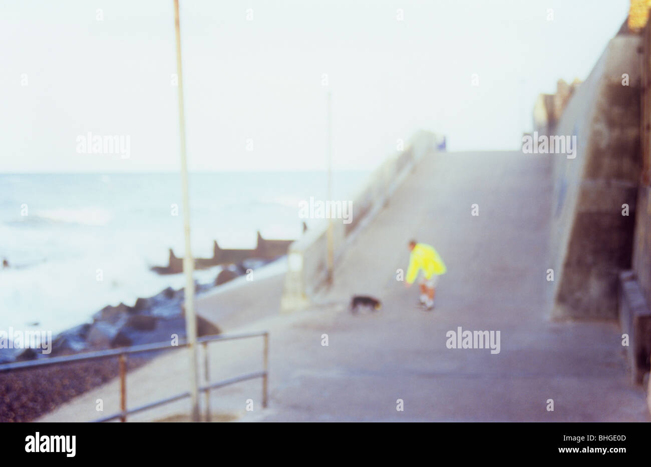 Impressionistic view of rocky beach and sea with concrete promenade ...