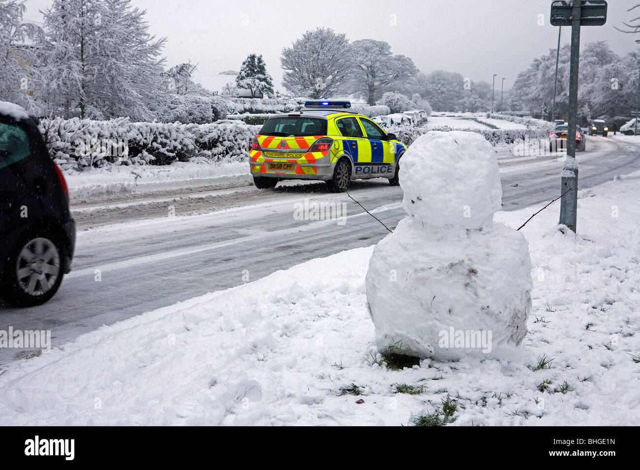 Police car drives along a snow covered road on its way to an emergency ...