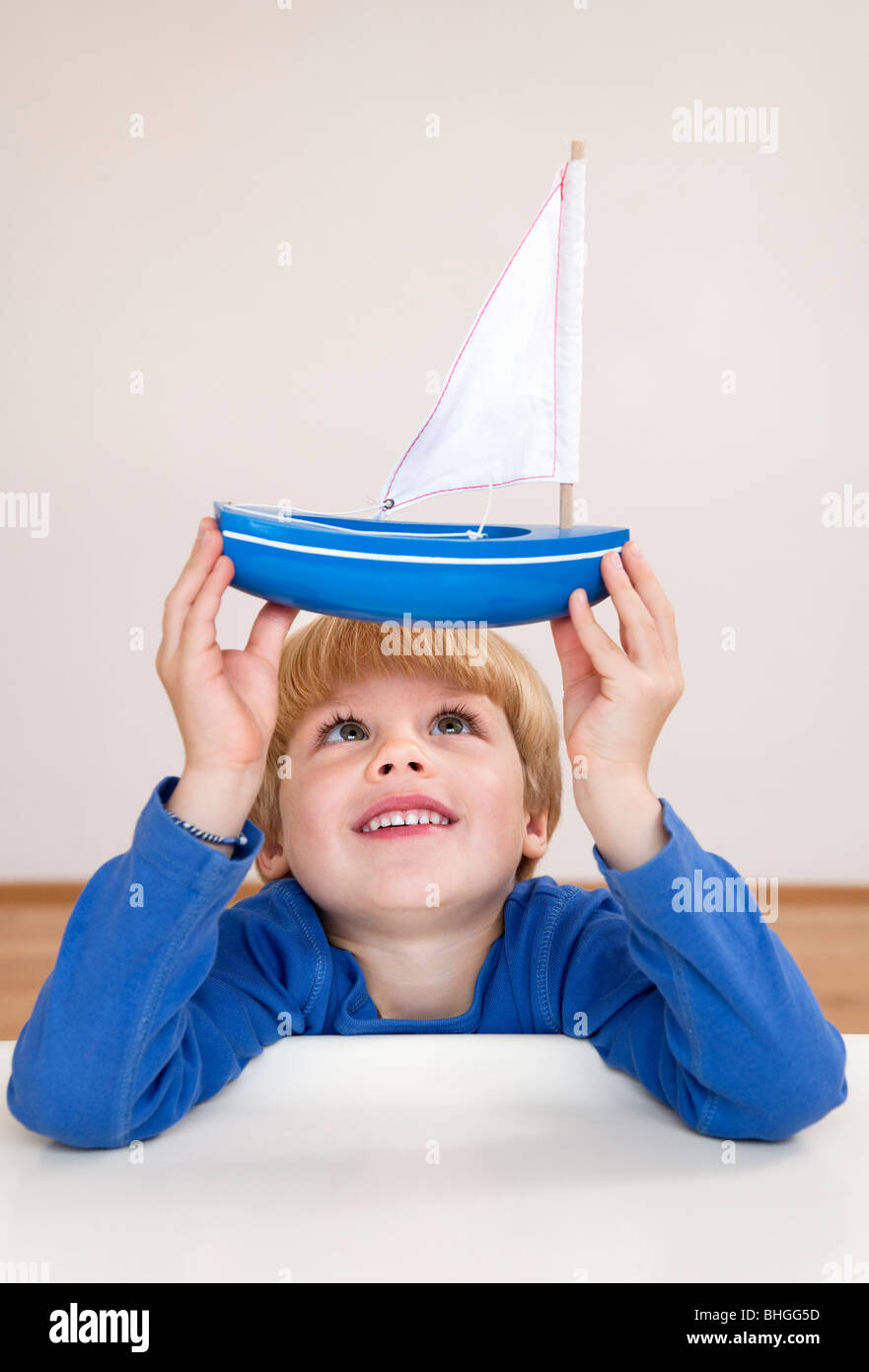 Boy holding toy boat hi-res stock photography and images - Alamy