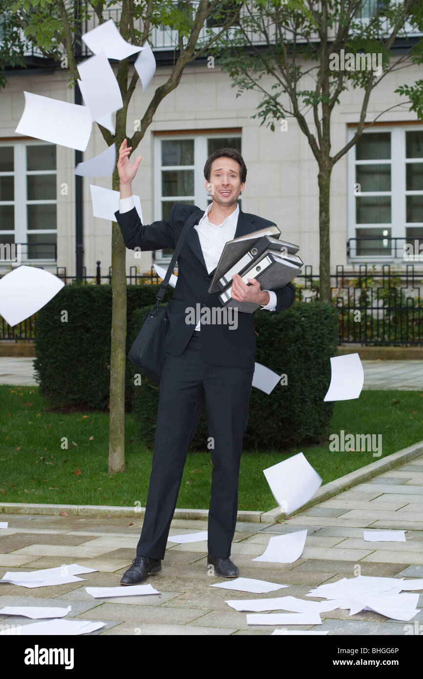 businessman surrounded by flying paper Stock Photo - Alamy