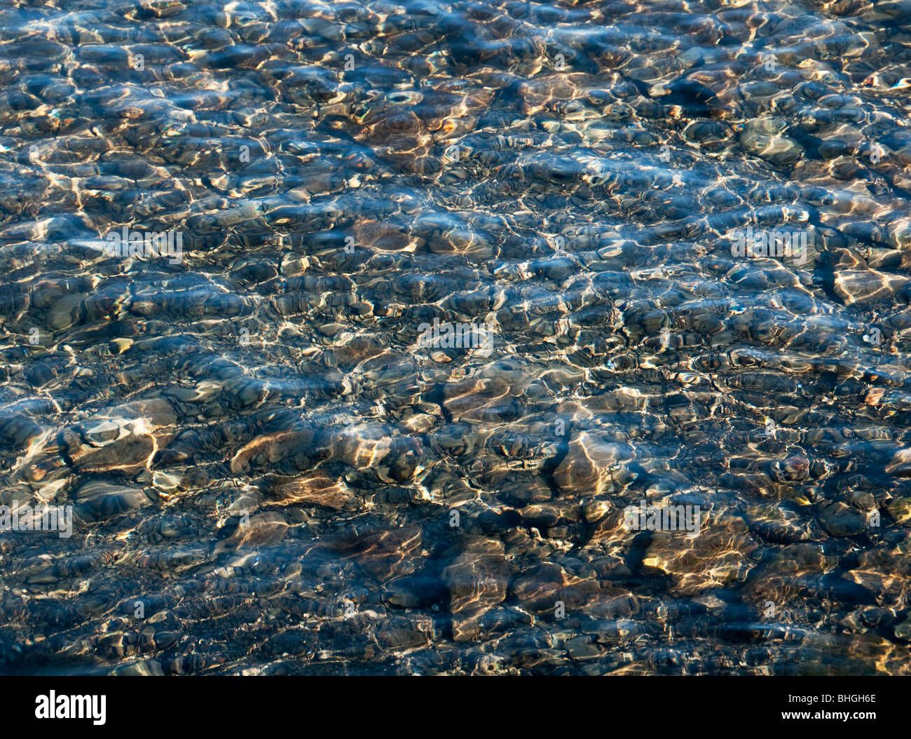 Pebbles under rippled water Stock Photo - Alamy