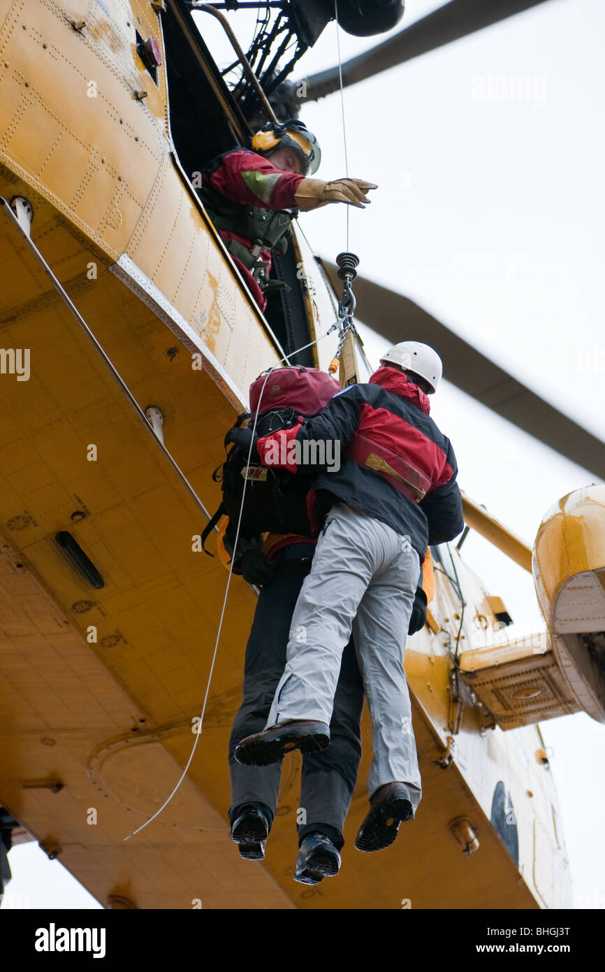 Mountain Rescue Volunteers being winched into a helicopter Stock Photo ...