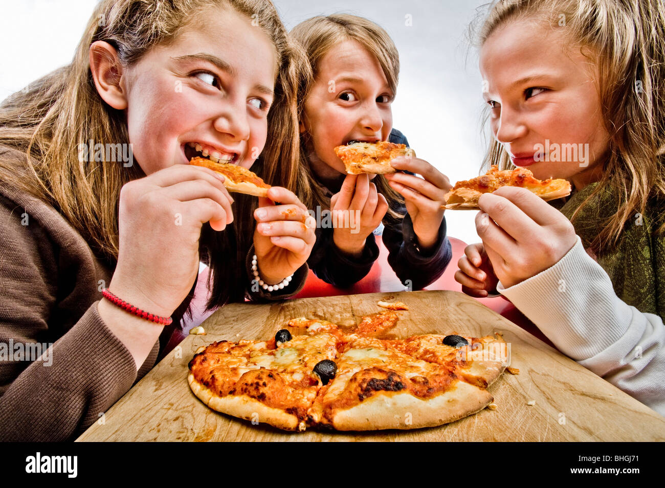 3 teenagers eating pizza Stock Photo - Alamy