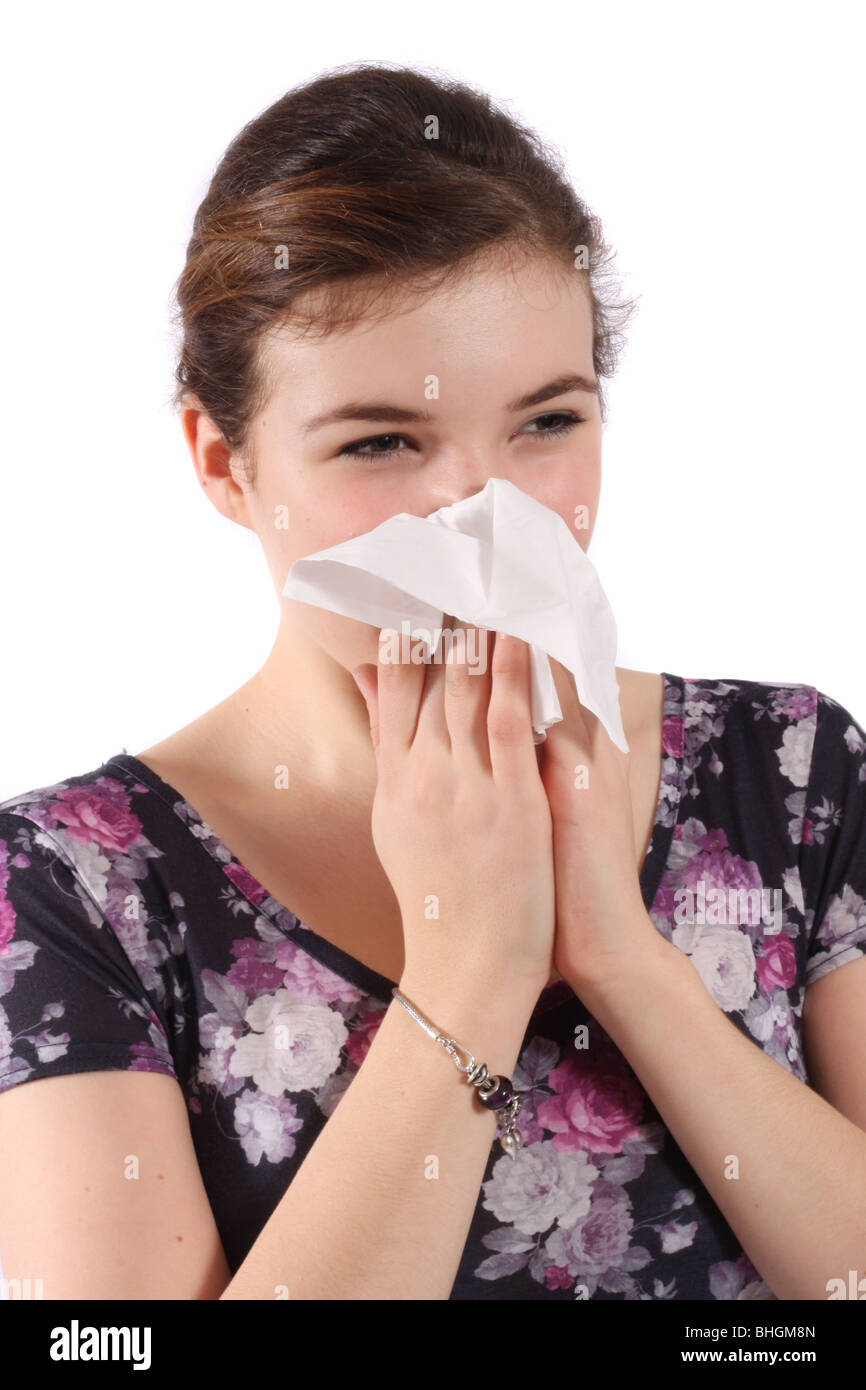 A teenage girl blowing her nose with a tissue Stock Photo - Alamy