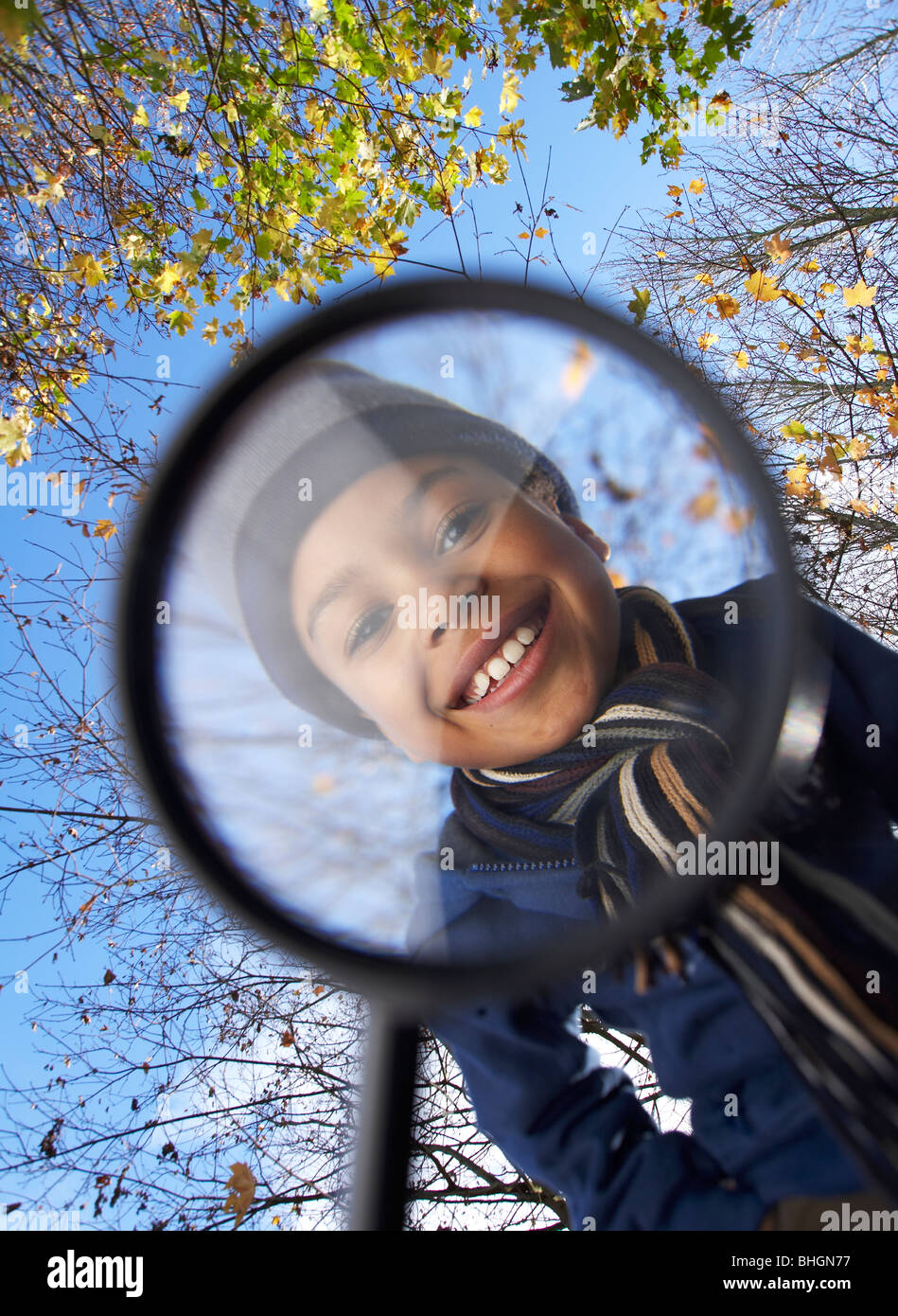 Boy looking through magnifying glass Stock Photo - Alamy