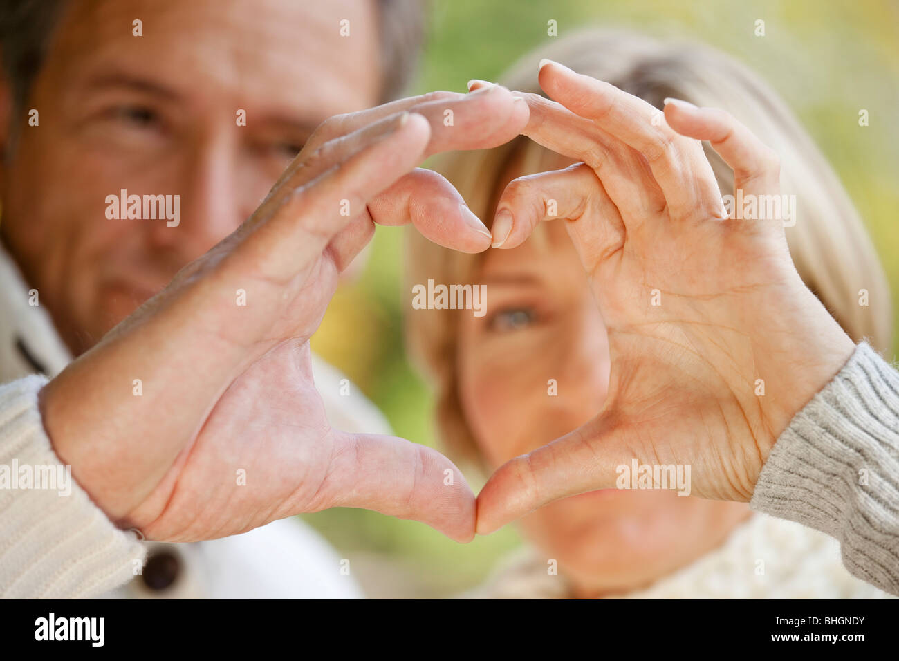 Couple forming heart with their fingers Stock Photo - Alamy
