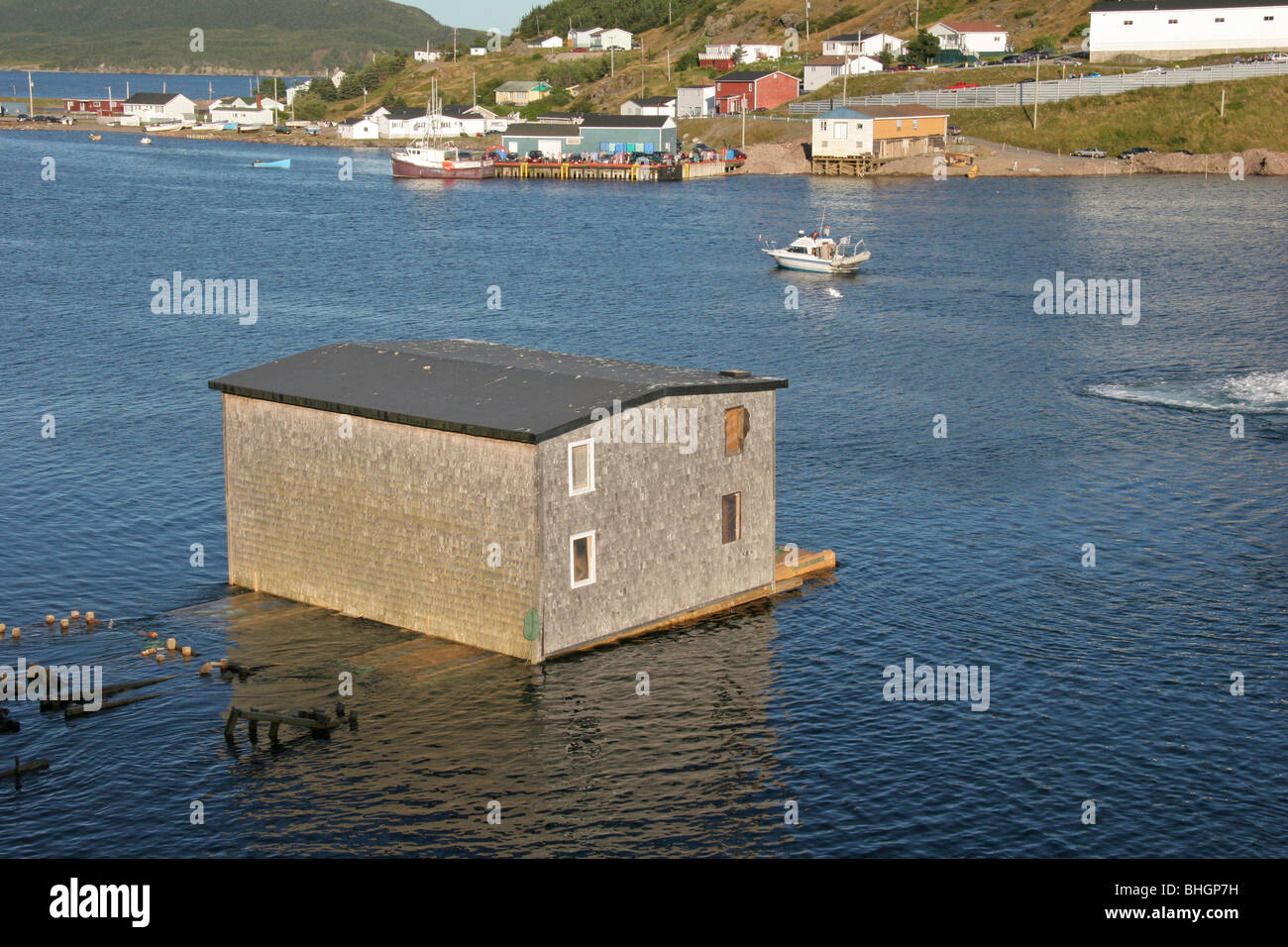 Men of Harbour Breton, Newfoundland float a building across the harbour ...