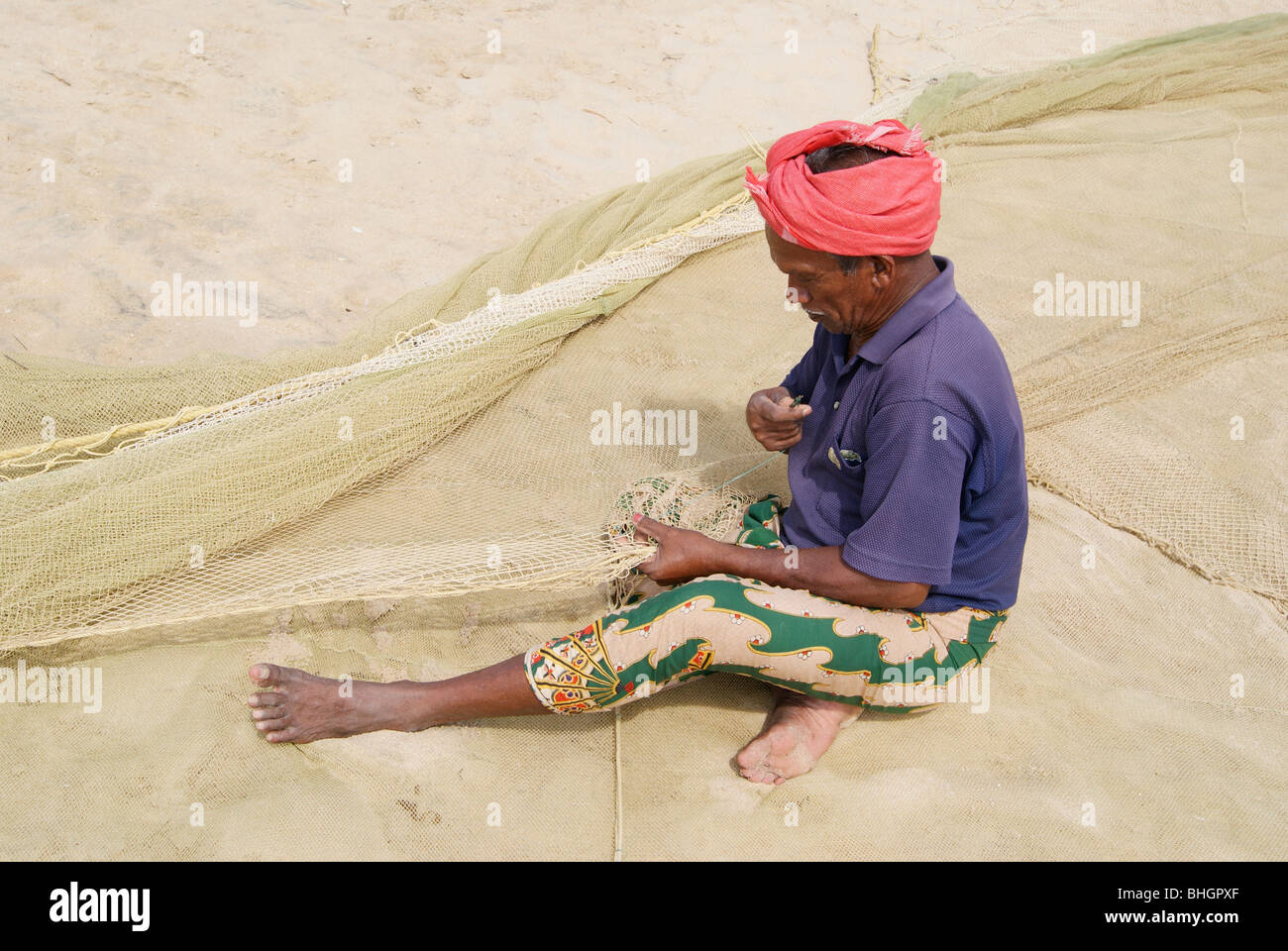 Native Fishermen weaving his fishing net in sea shore fishing Beach of ...
