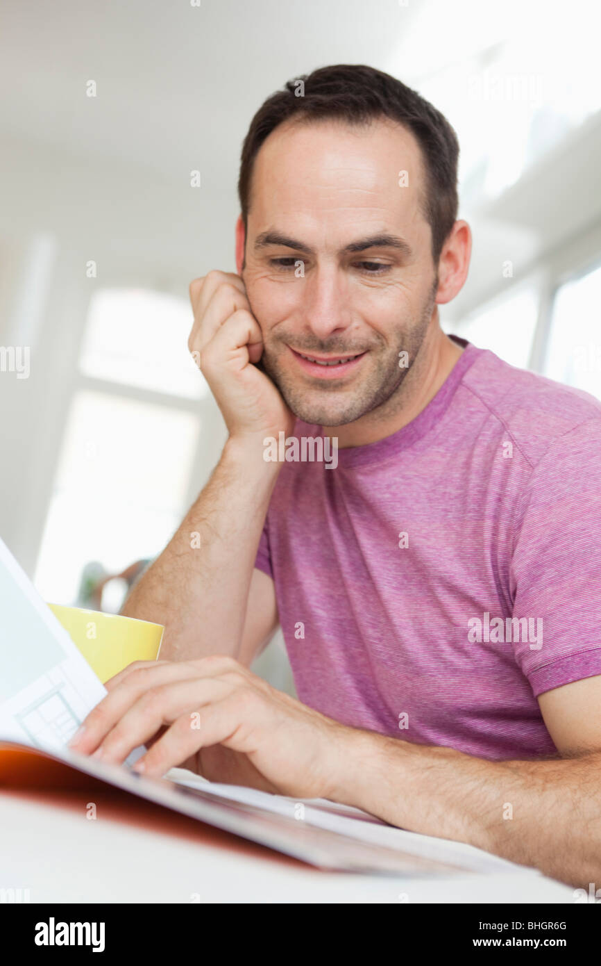 man sitting at table reading brochure Stock Photo - Alamy
