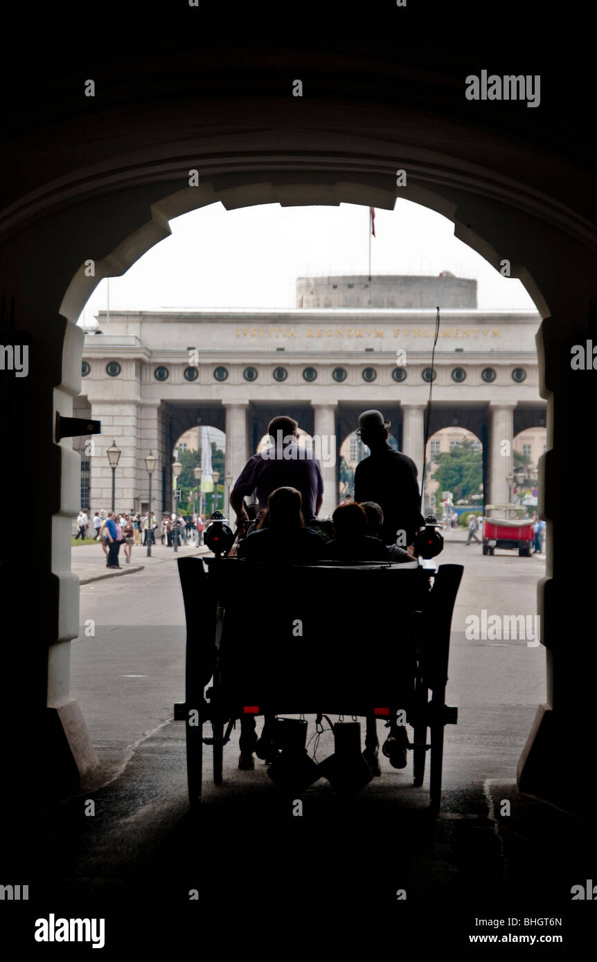 A Viennese Fiaker horse carriage drives through the gates at Hofburg ...
