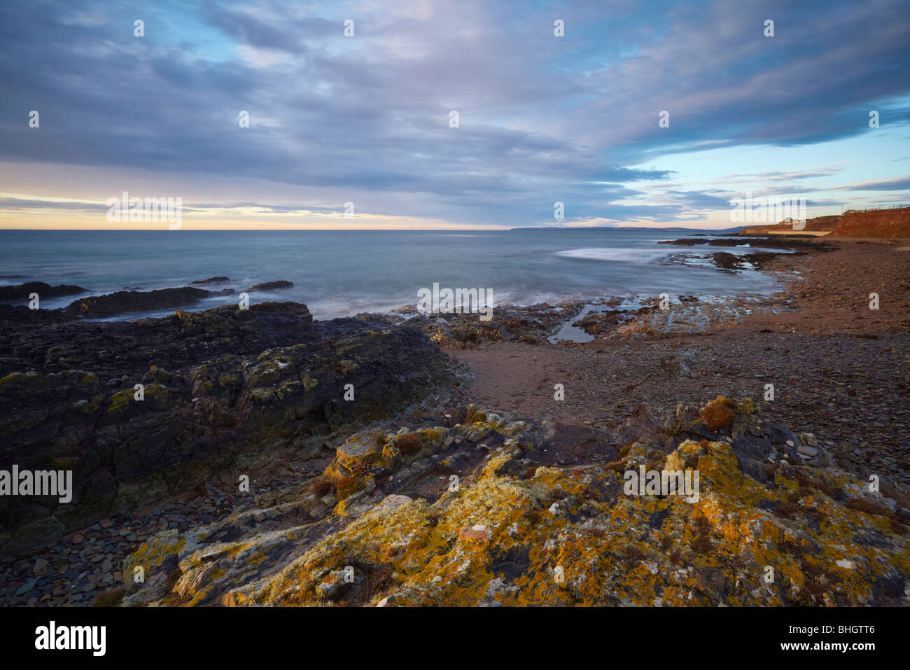 morning sunlight illuminates the shoreline on Guileen Strand, Co.Cork ...