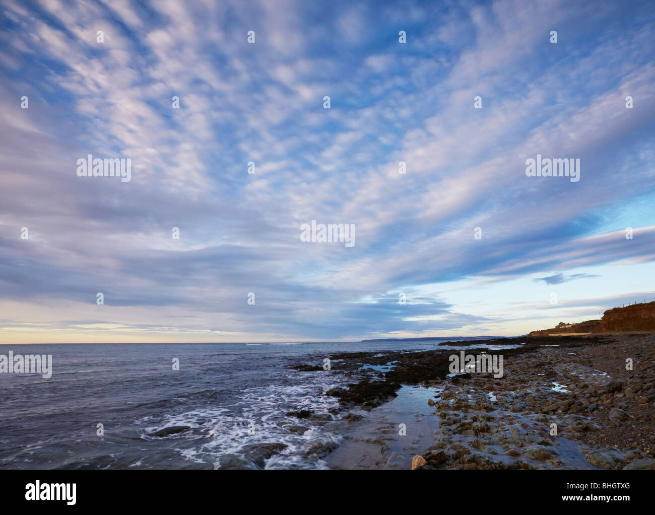 morning sunlight illuminates the shoreline on Guileen Strand, Co.Cork ...