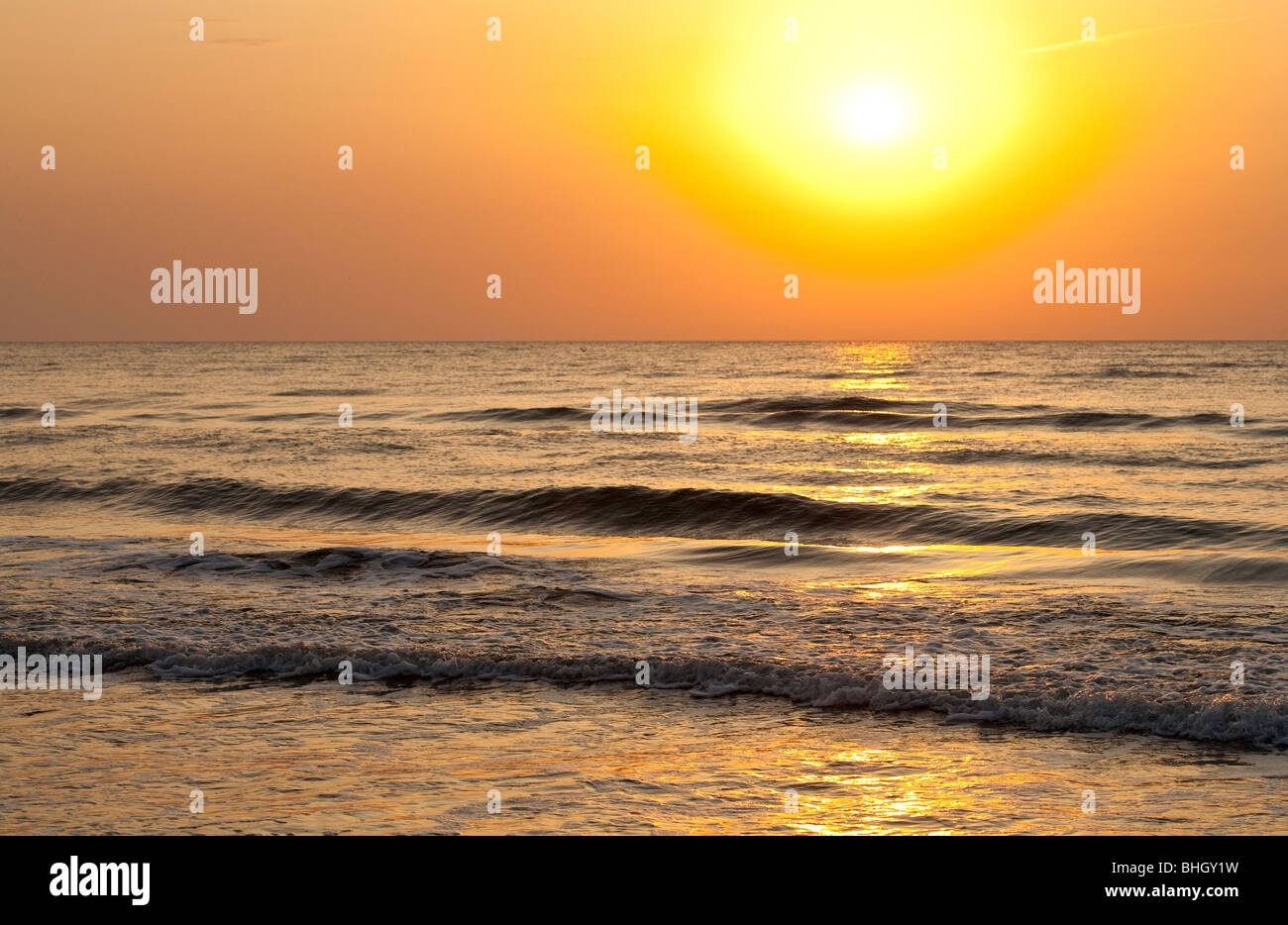 Sunrise with beautiful colors at the sea shore Stock Photo - Alamy