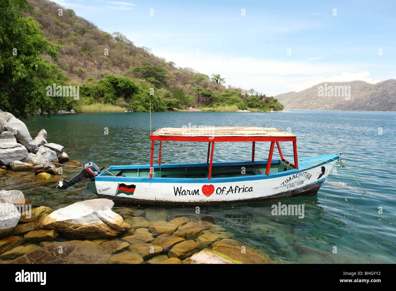 A boat floats on the clear water of Lake Malawi near Cape Maclear with ...