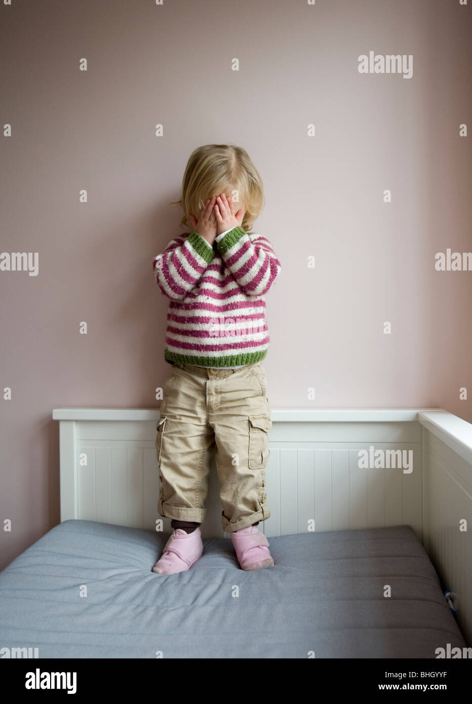 GIRL TODDLER WITH HANDS OVER FACE Stock Photo - Alamy