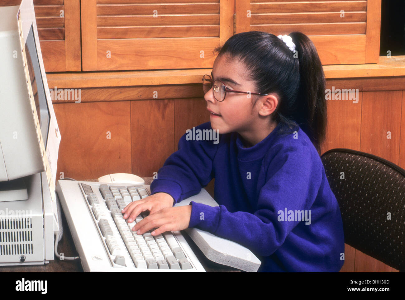 Hispanic young girl type home PC computer keyboard alert attentive ...