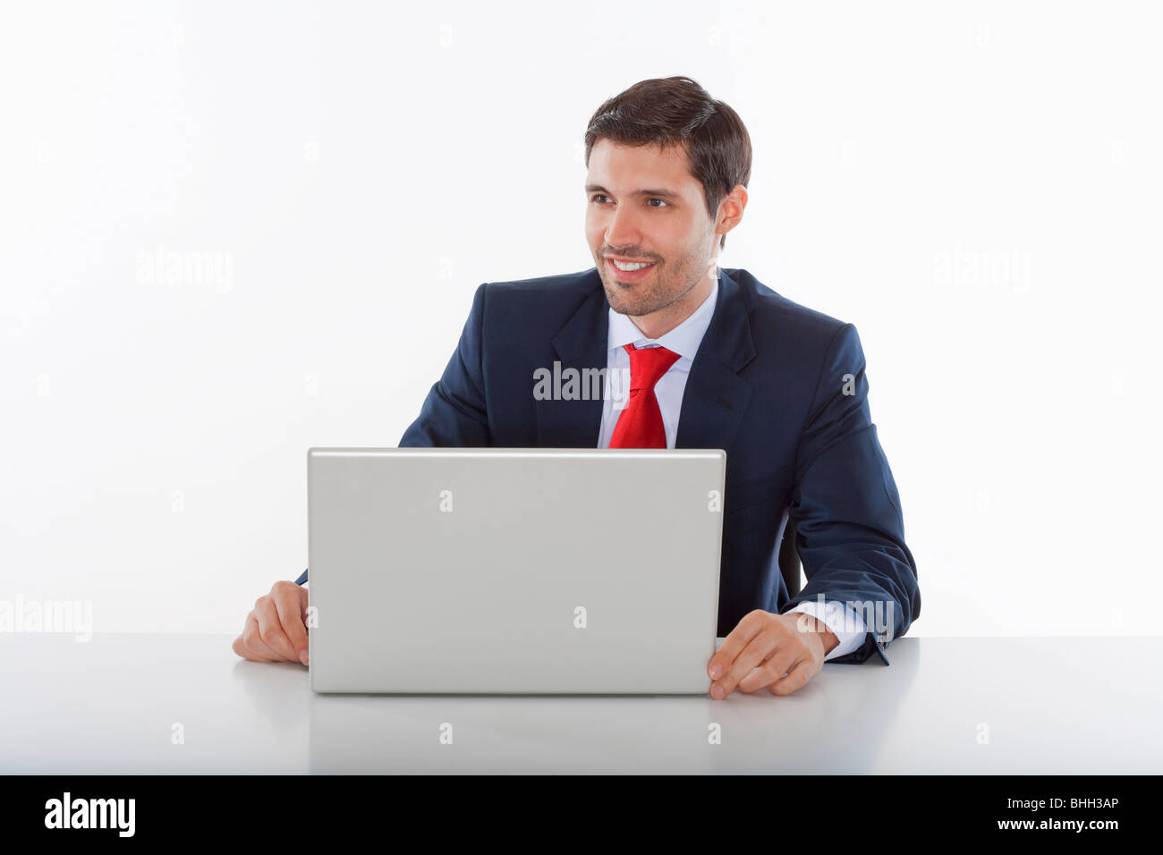 young business executive in suit behind desk with laptop Stock Photo ...