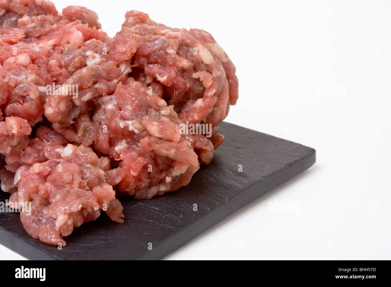 Ground or minced beef from low viewpoint up close against white ...
